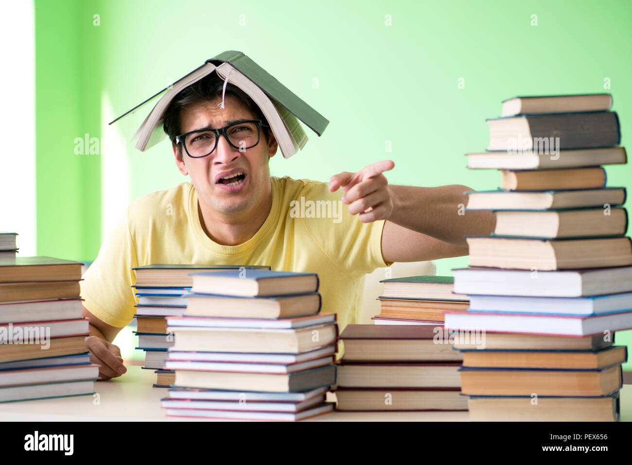 Student with too many books to read before exam Stock Photo - Alamy
