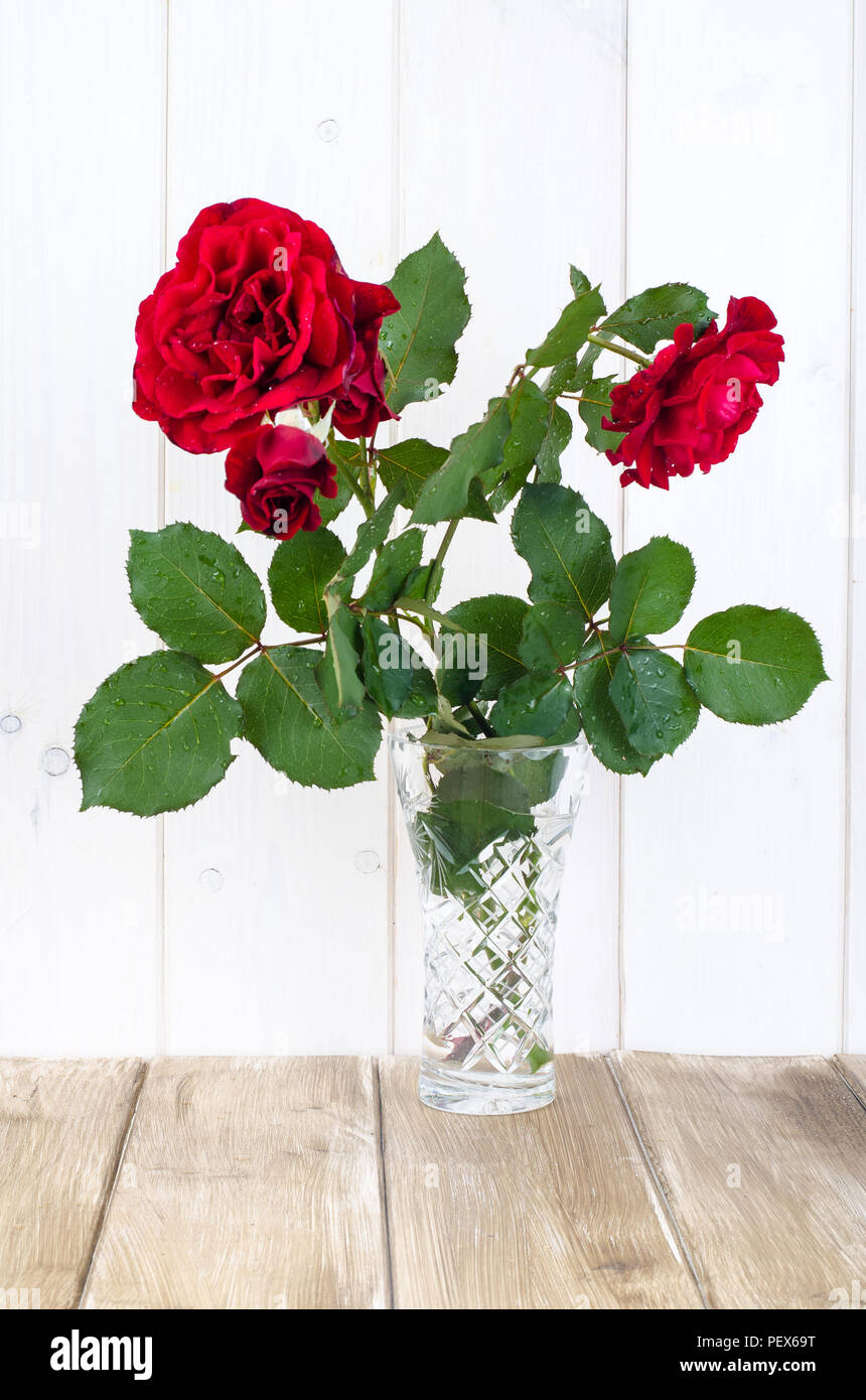Vintage crystal vase with rose on rustic table. Studio Photo Stock ...