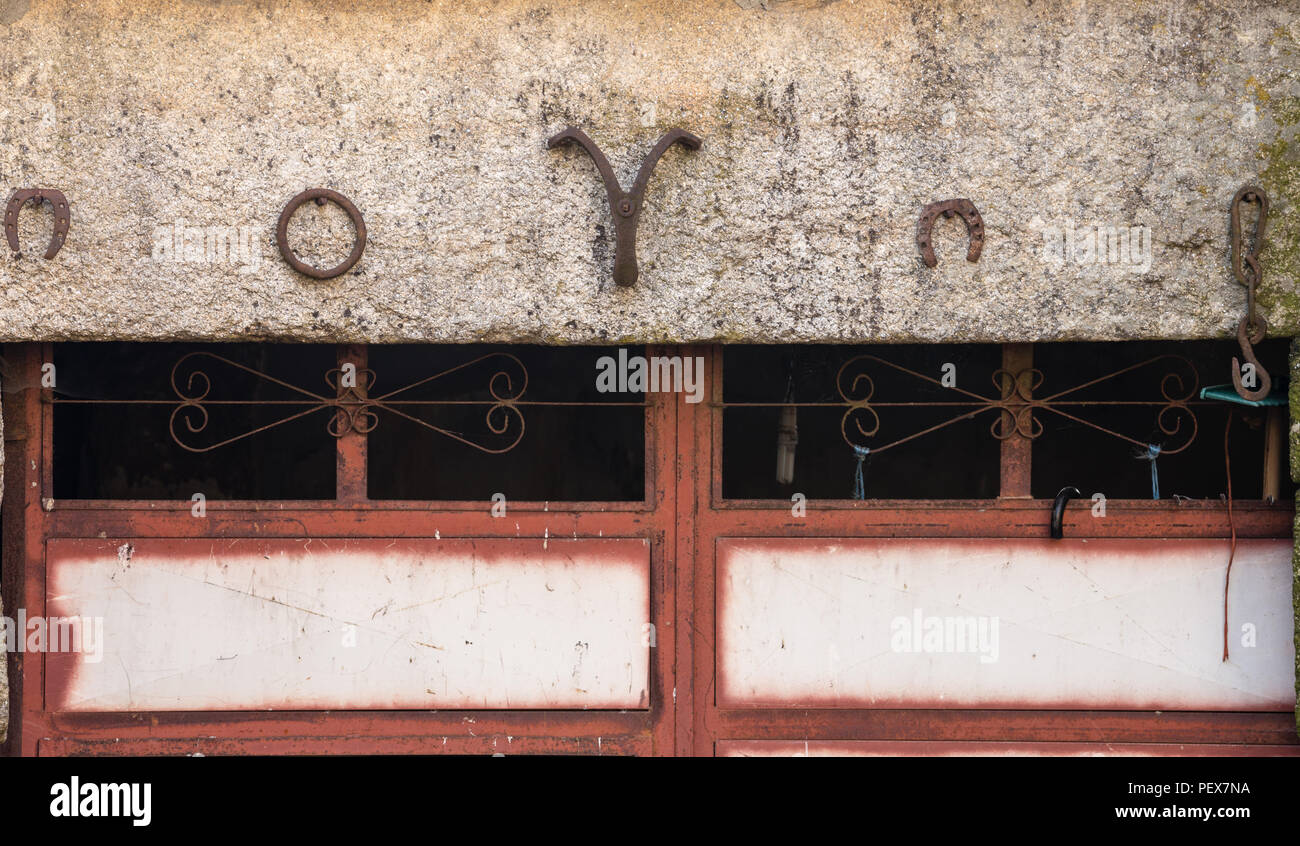 Traditional village scene with old blacksmith sign and horseshoe and ...