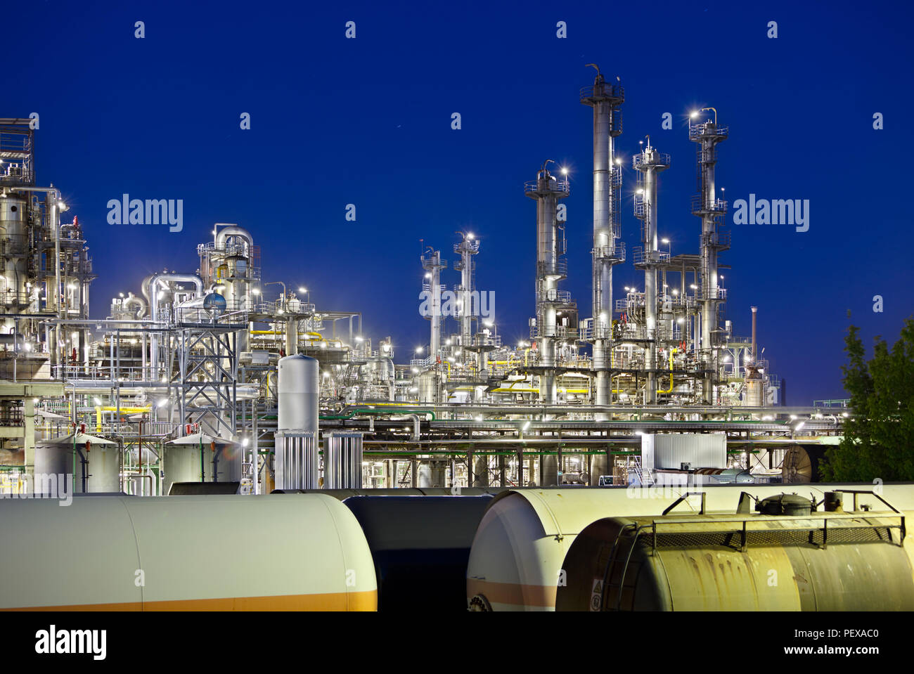A large oil refinery with railroad cars as foreground at night Stock ...