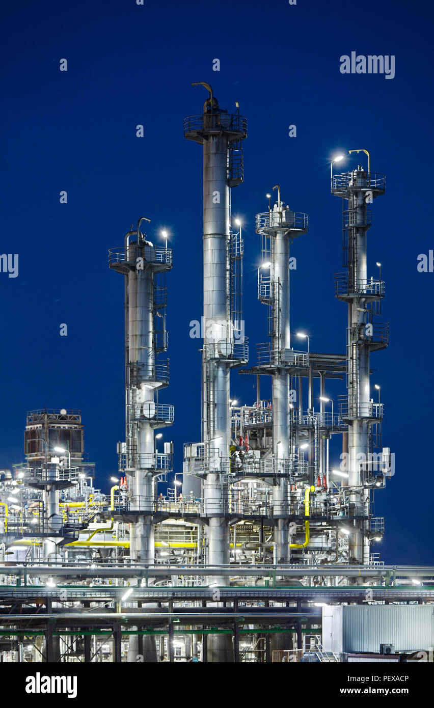 Vertical shot of an oil refinery with night blue sky Stock Photo - Alamy