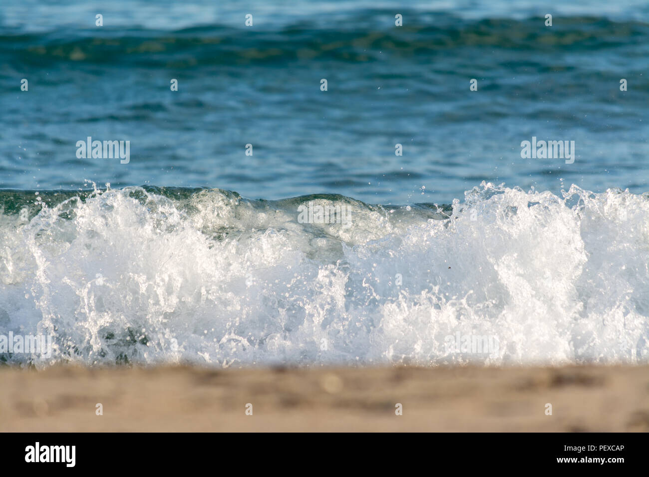 Crystal clear waves on the sand of the beach in summer Stock Photo - Alamy