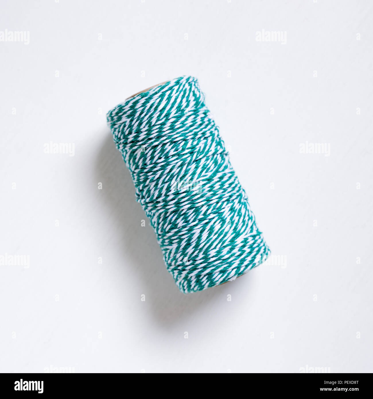 Green thread reel on white background Stock Photo - Alamy