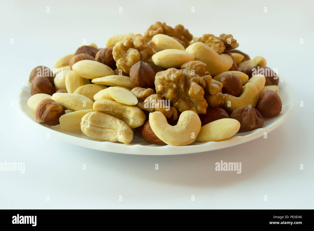 Nuts mixture - hazelnuts almonds walnuts cashew on a plate on a white ...