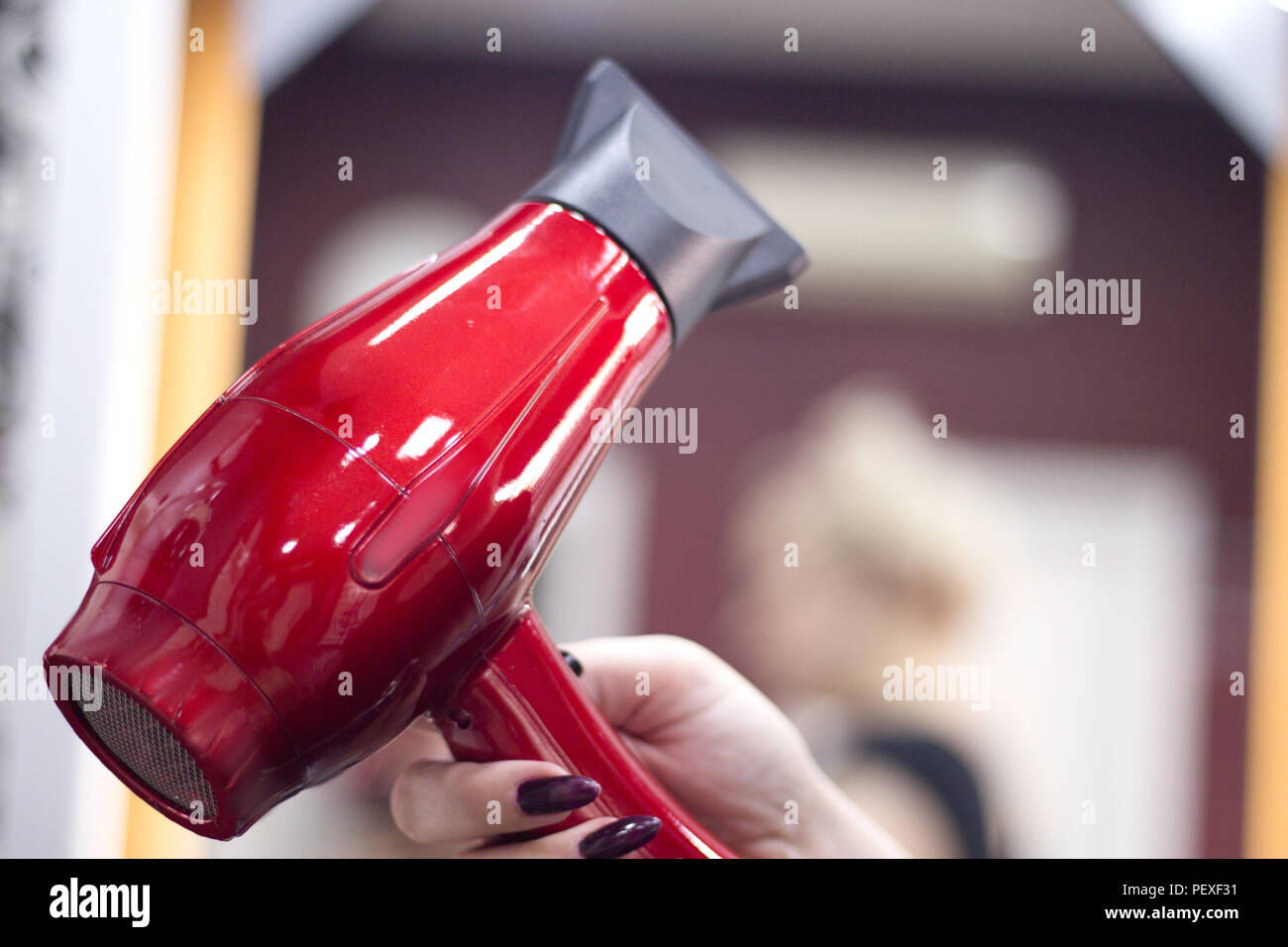 Hairdresser drying hair with red hand dryer Stock Photo - Alamy
