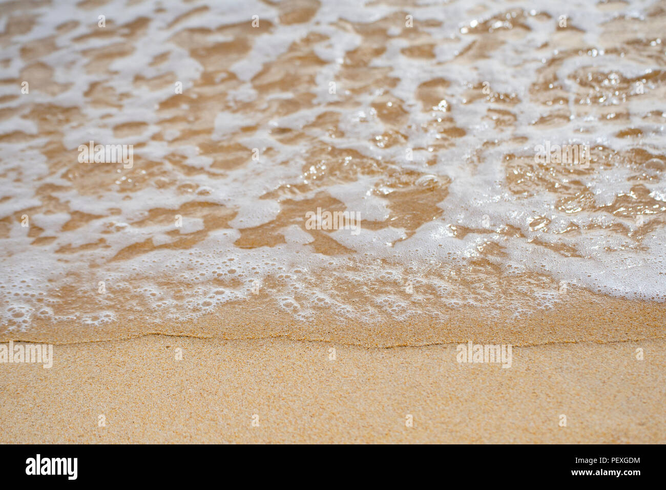 Wave of ocean on sandy beach background Stock Photo - Alamy