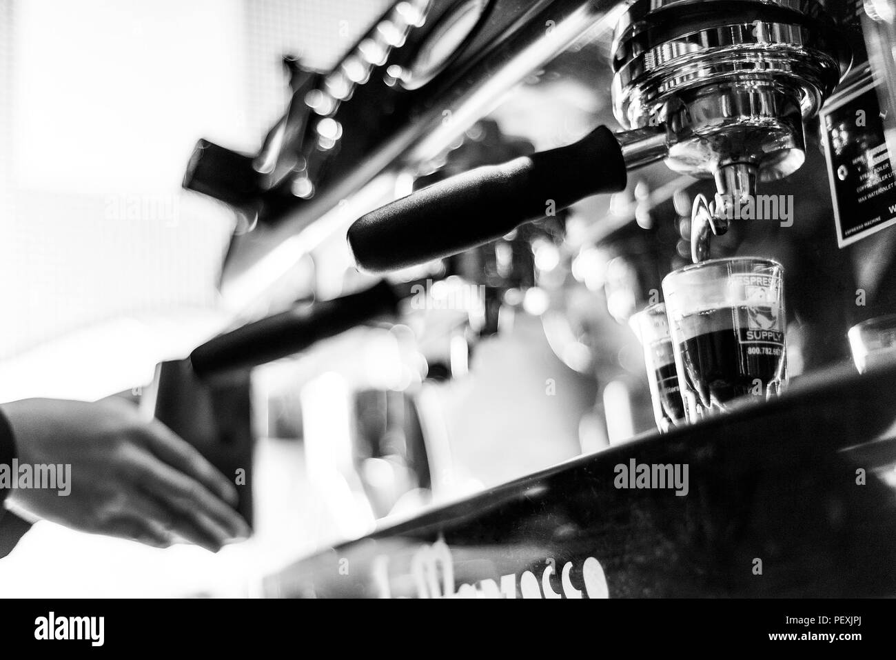 making espresso coffee BW black and white close up detail with modern ...