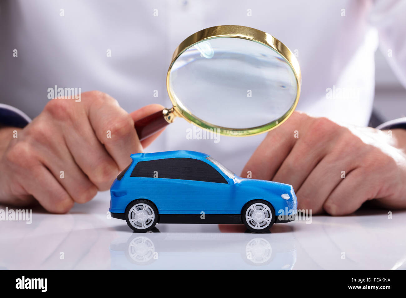Businessman's Hand Holding Magnifying Glass Over Small Blue Car Stock ...