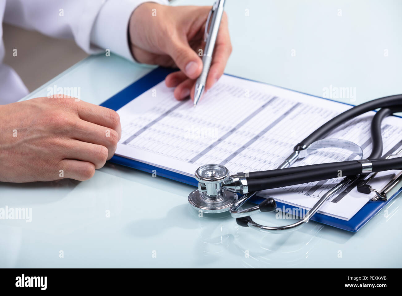 Doctor Working On Document With Stethoscope On Desk Stock Photo - Alamy