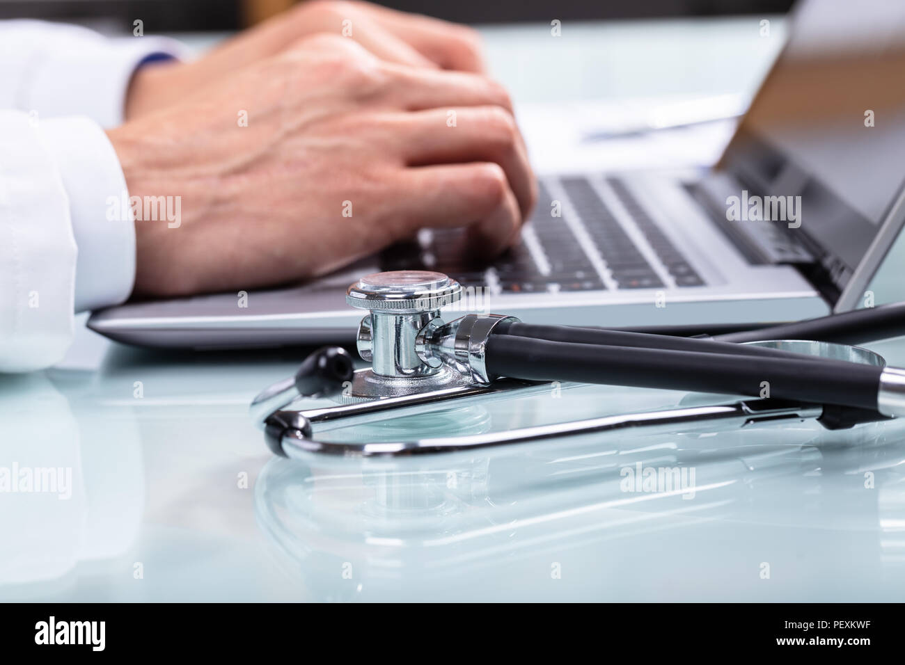 Doctor Using Laptop With Stethoscope On Desk Stock Photo - Alamy