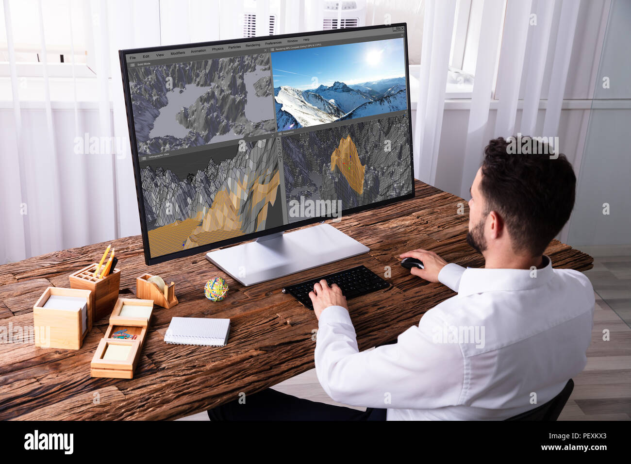 Young Man Editing 3D Landscape On Computer Over Wooden Desk Stock Photo ...