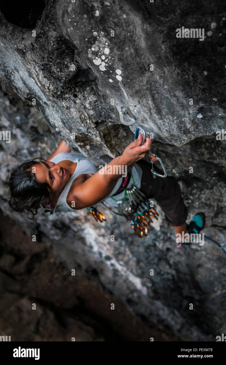 Woman rock climbing up cliff Stock Photo - Alamy