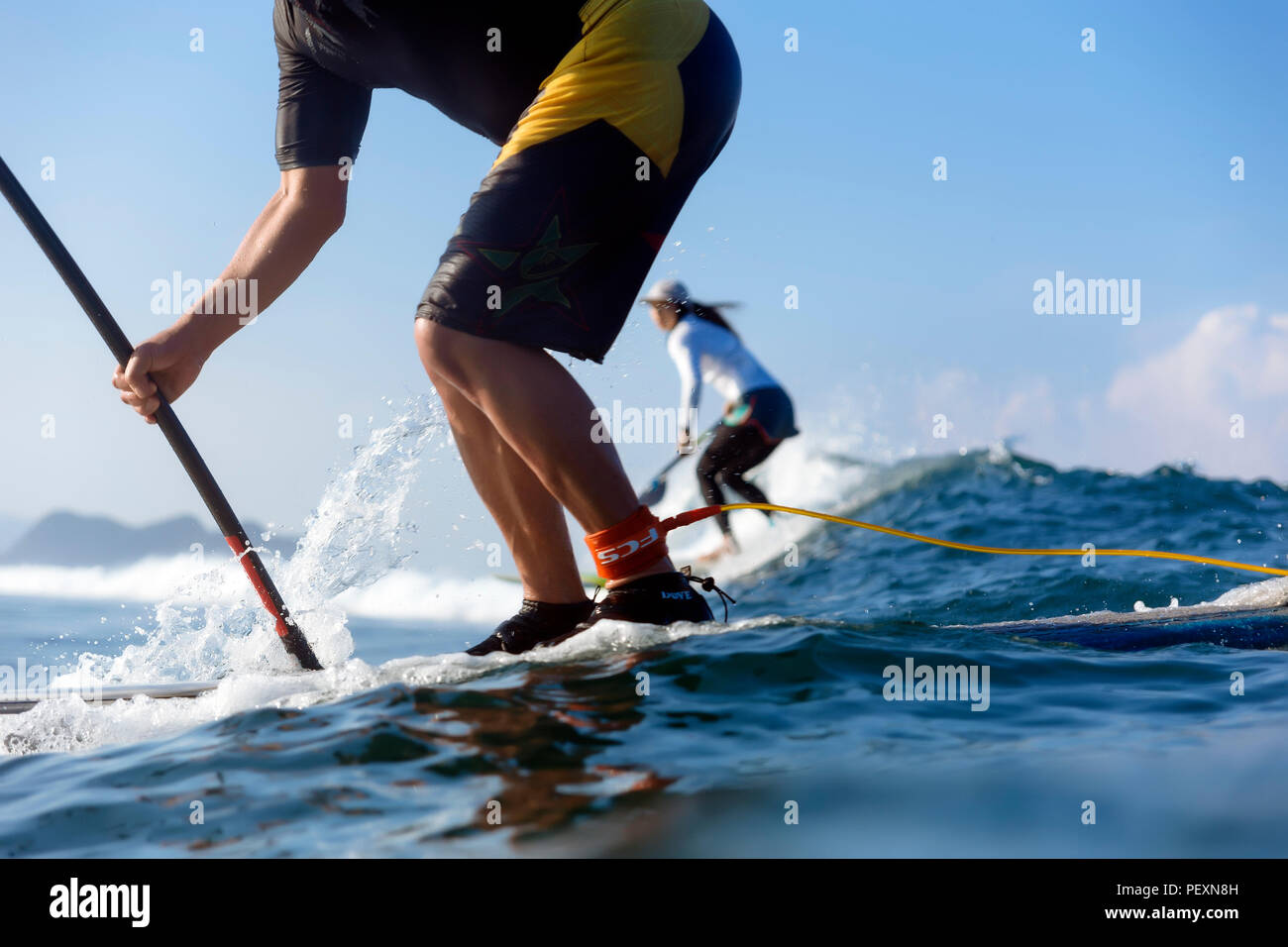 Two people paddle surfing in sea Stock Photo - Alamy