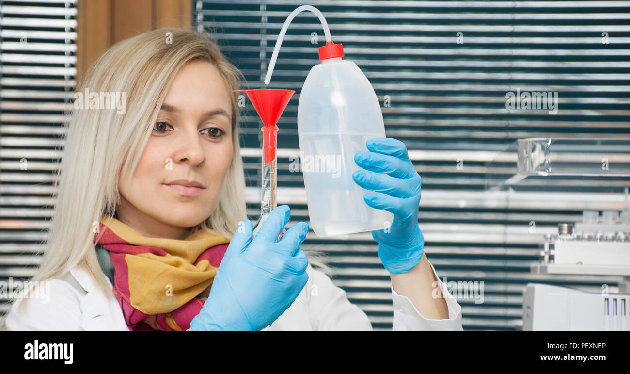 Portrait of a chemist holding a tube with liquid Stock Photo - Alamy