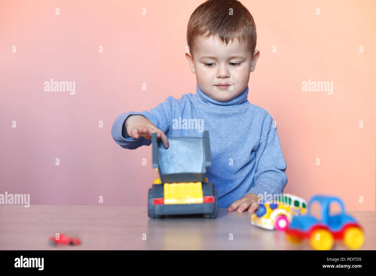 A cute little boy playing with model car collection. Toy mess in child ...