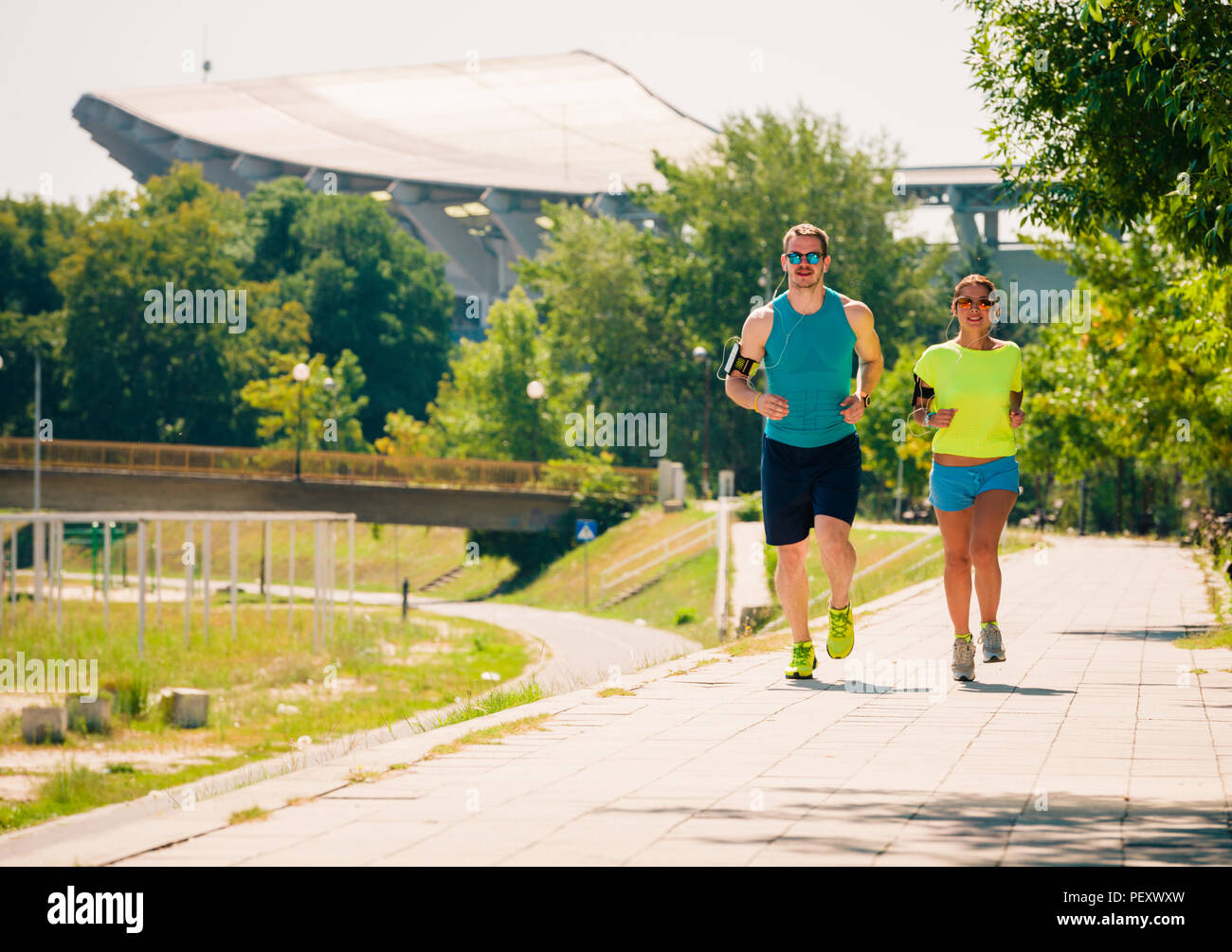 Two athletic people running through the riverside Stock Photo - Alamy