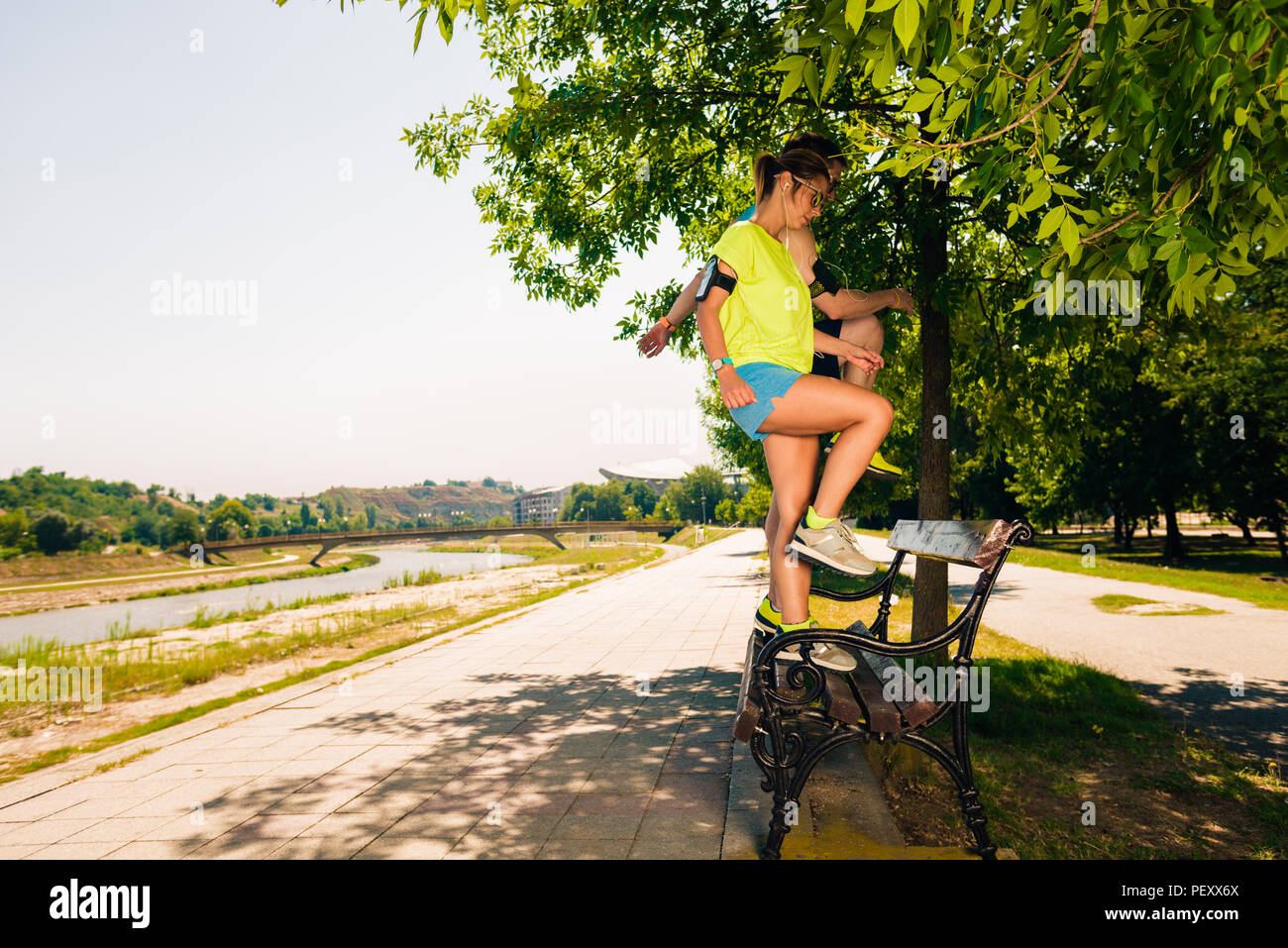 Athletic young couple doing stretching legs exercises together on the ...
