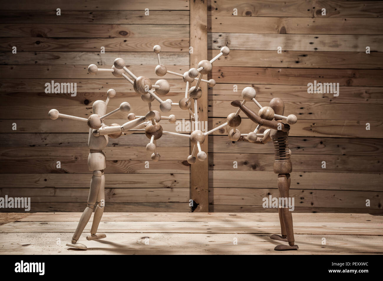 wooden puppets with atom construction on wood table in wood scene Stock ...