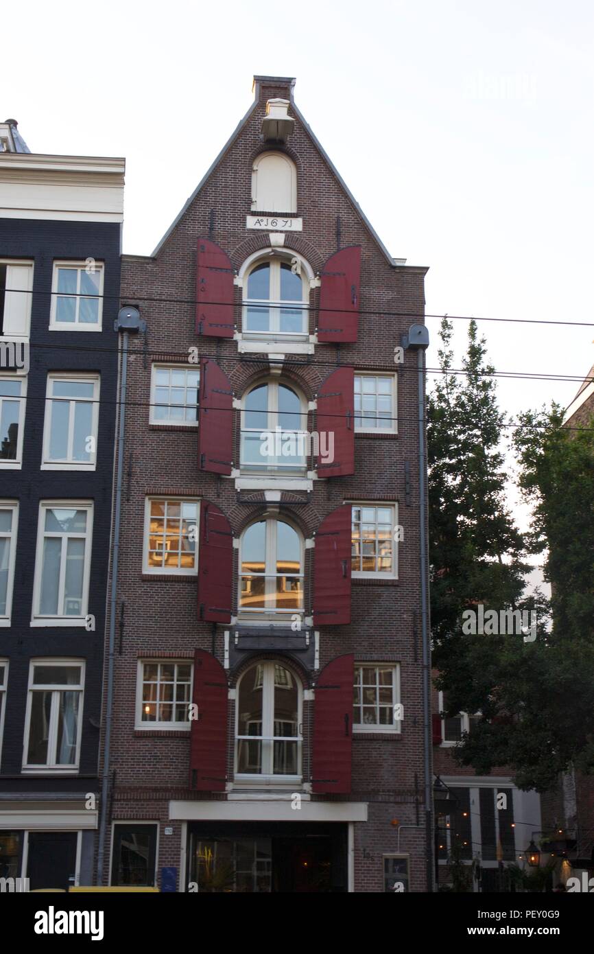 A traditional Amsterdam apartment building with red wooden window ...