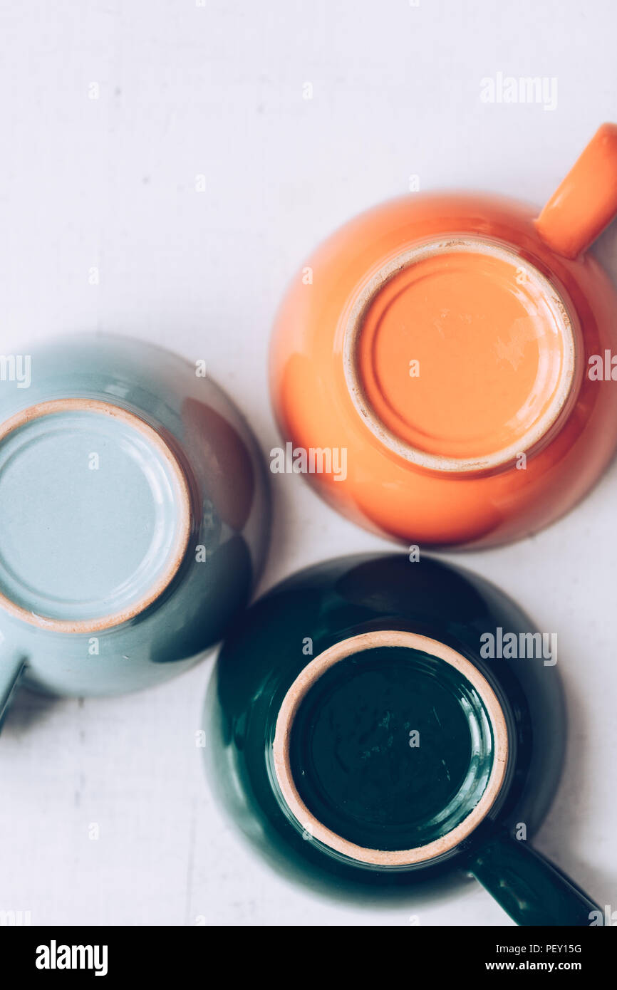 Top view of three colorful cups on grey background. Abstract ...