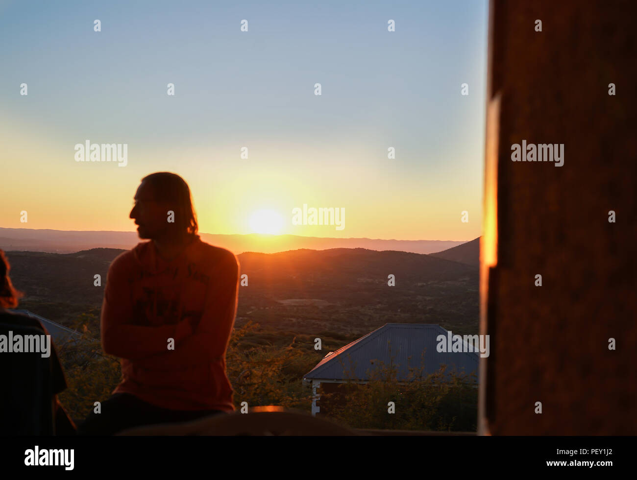 Silhouette of person in profile standing in front of landscape with ...