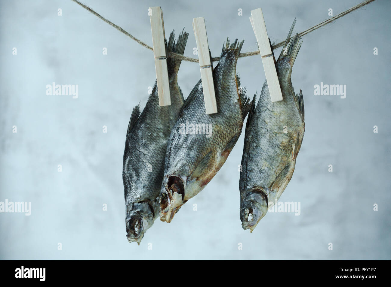 Dried fish on a rope. Food concept. Ideal appetizer for beer. Rustic ...