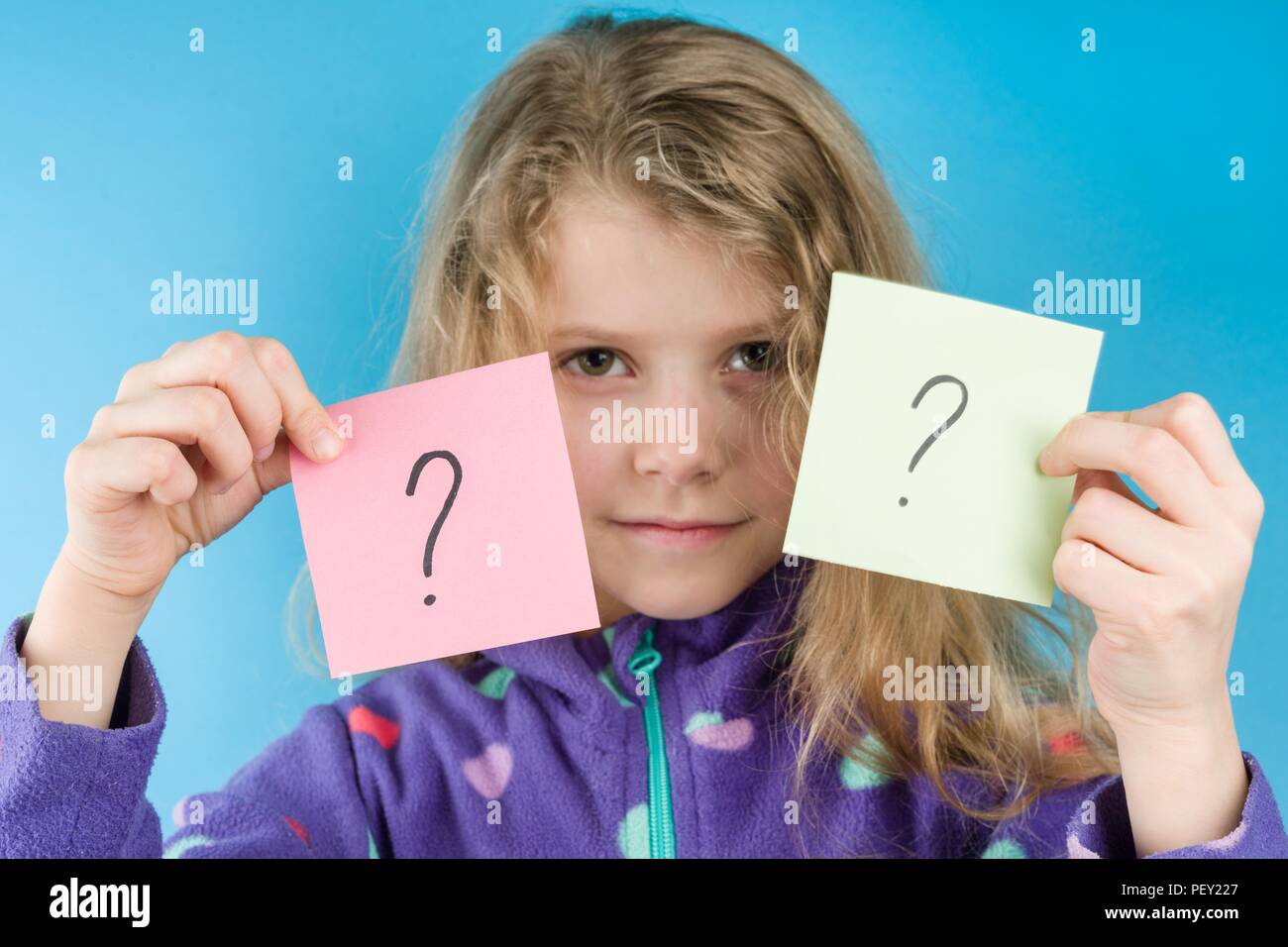Girl holding stickers with question marks, Blue background Stock Photo ...