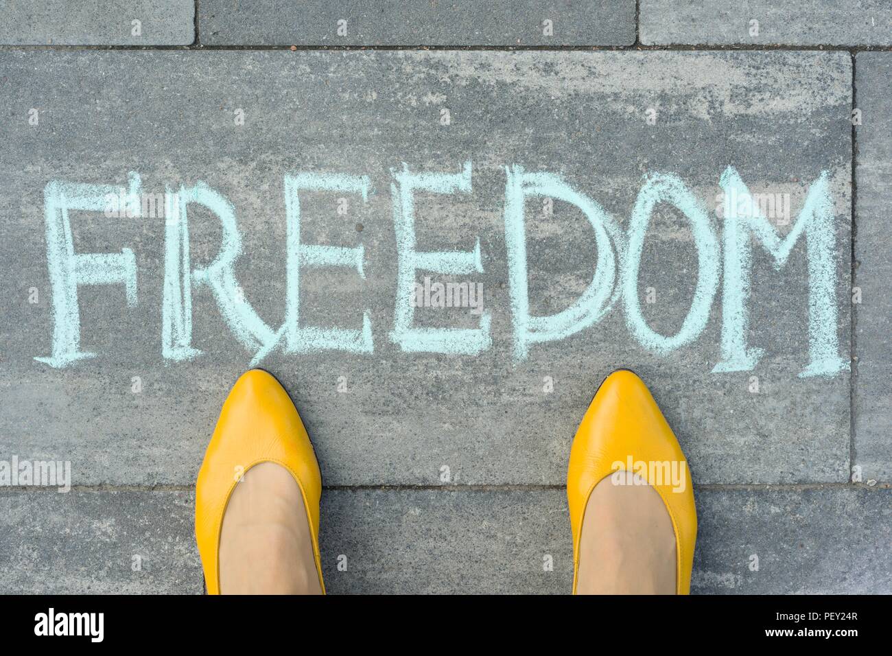 Female feet with text freedom written on grey sidewalk Stock Photo - Alamy