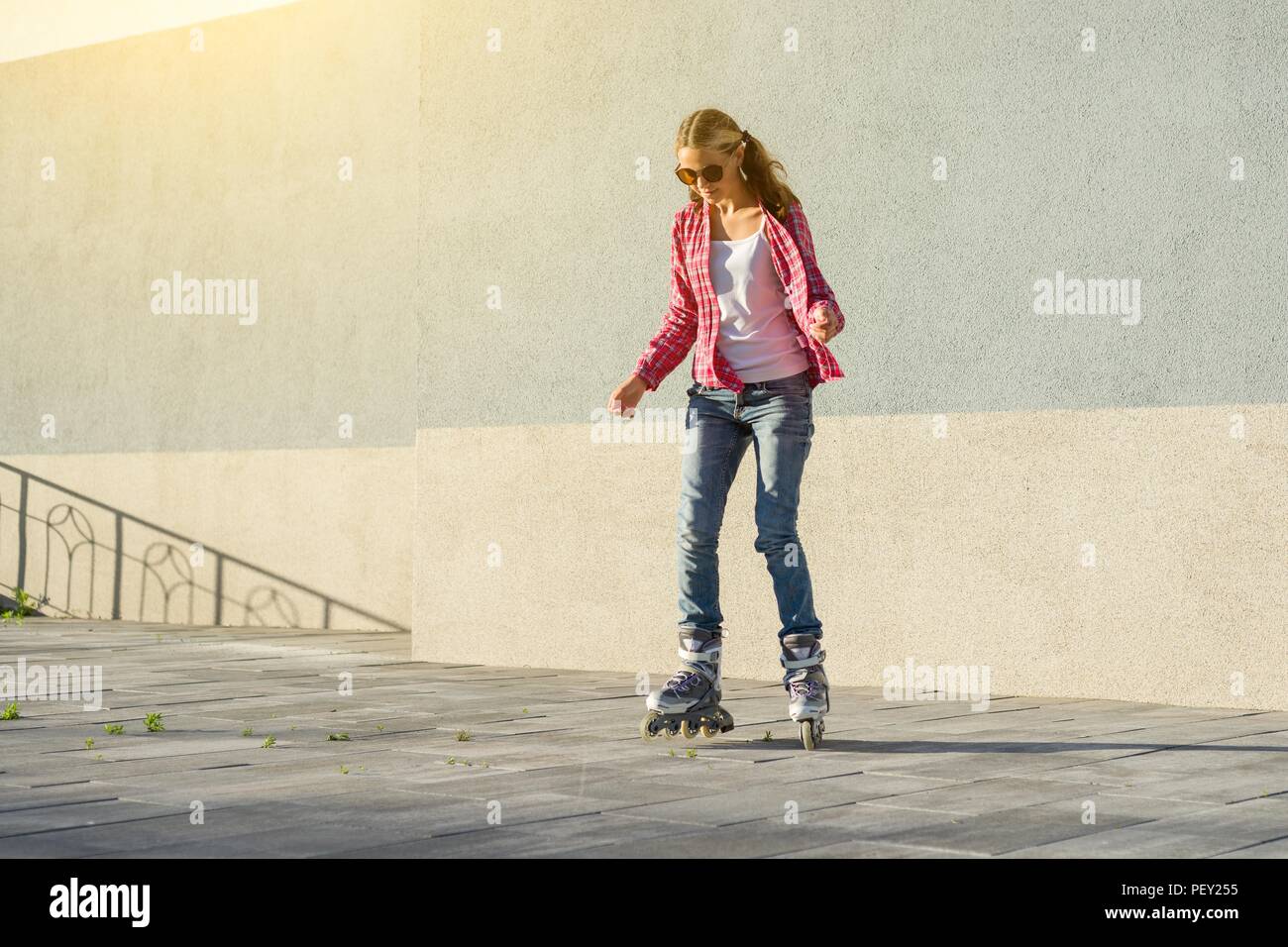 Active sports girl teen in roller skates on the urban background Stock ...