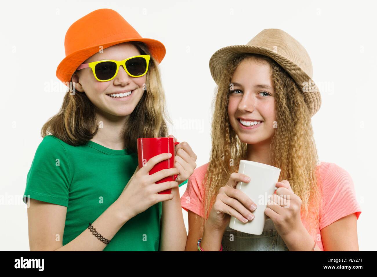 Girls girlfriends 12-14 years old, on a white background in hats ...