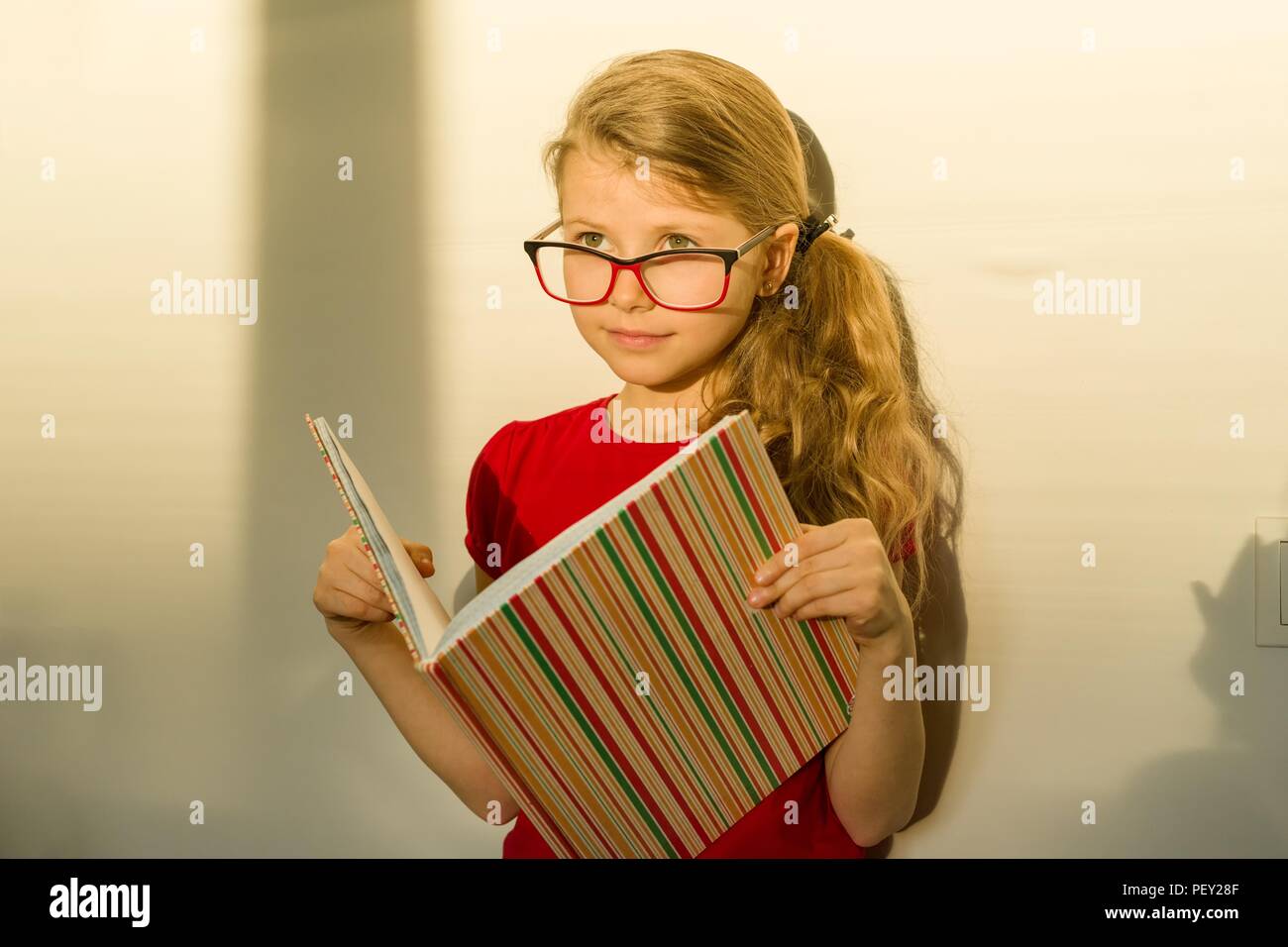 Girl child elementary school student wearing glasses is holding a ...