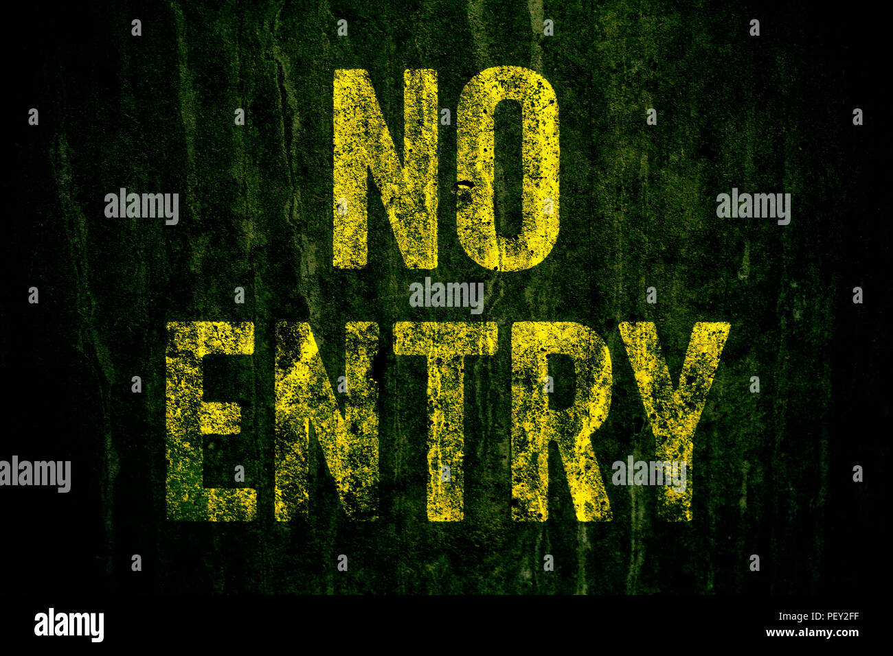 “No Entry” warning sign in yellow letters painted over dark grungy ...