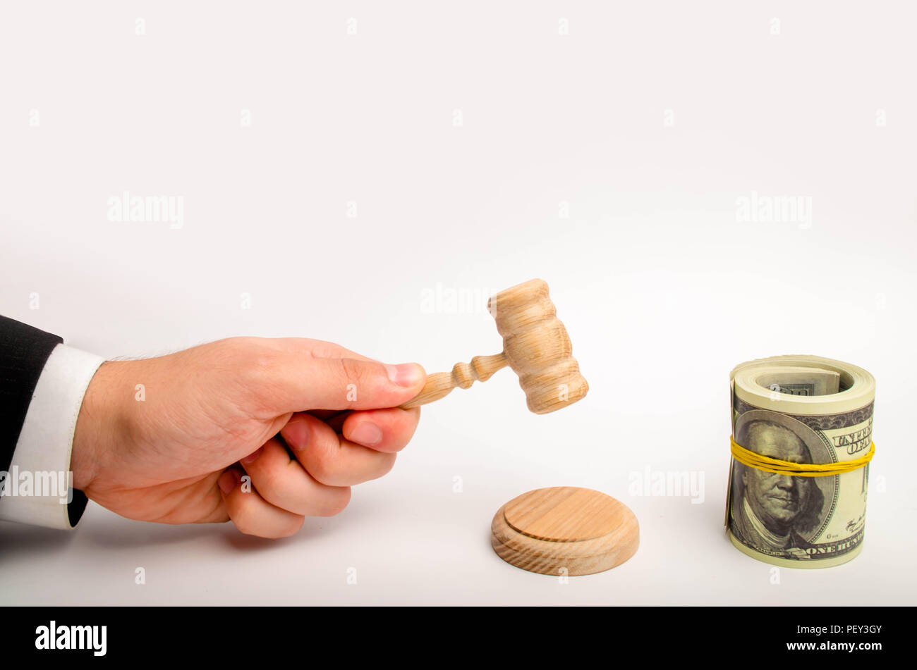 A wooden judge hammer and a bundled bundle of dollars on a white ...