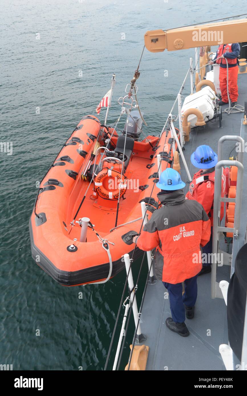 Crew members aboard the Coast Guard Cutter Naushon prepare to launch ...