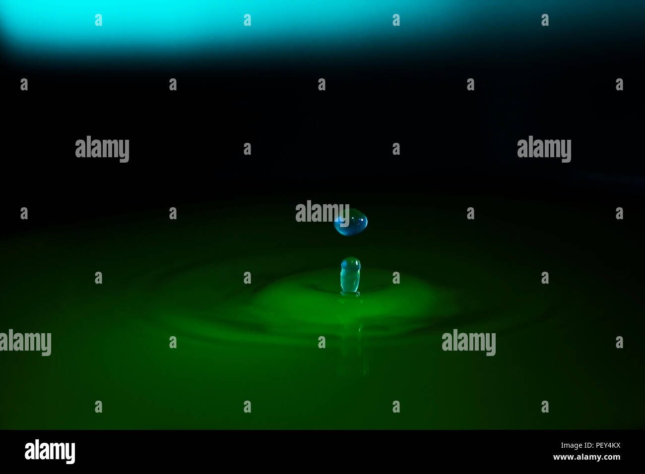 Water drop jumping out of green liquid in the dark Stock Photo - Alamy