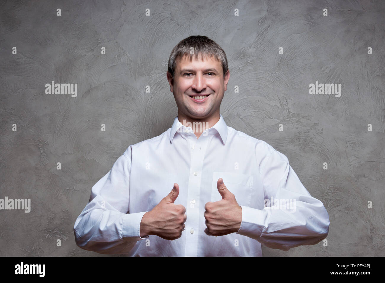 Man making a hand sign isolated on gray background Stock Photo - Alamy