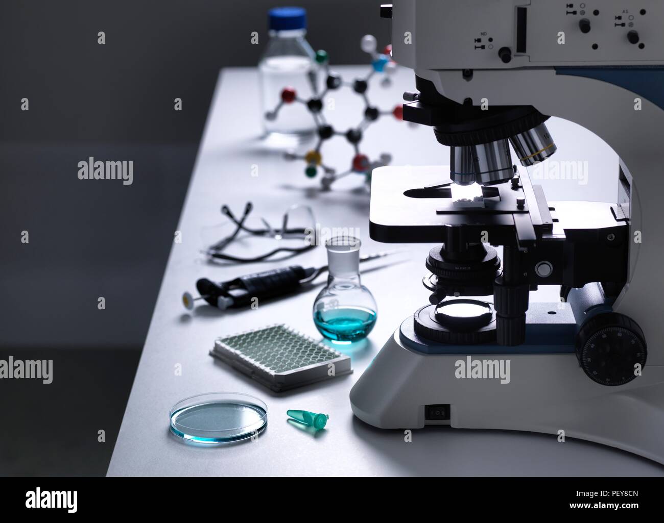Still life of a laboratory bench with a microscope and various ...