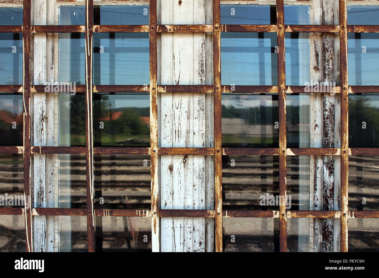 Rusted metal bars in shape of net mounted on old dilapidated white ...