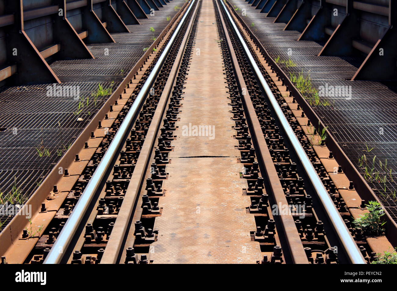 Strong old rusted metal railroad bridge with hard supports, metal grids ...