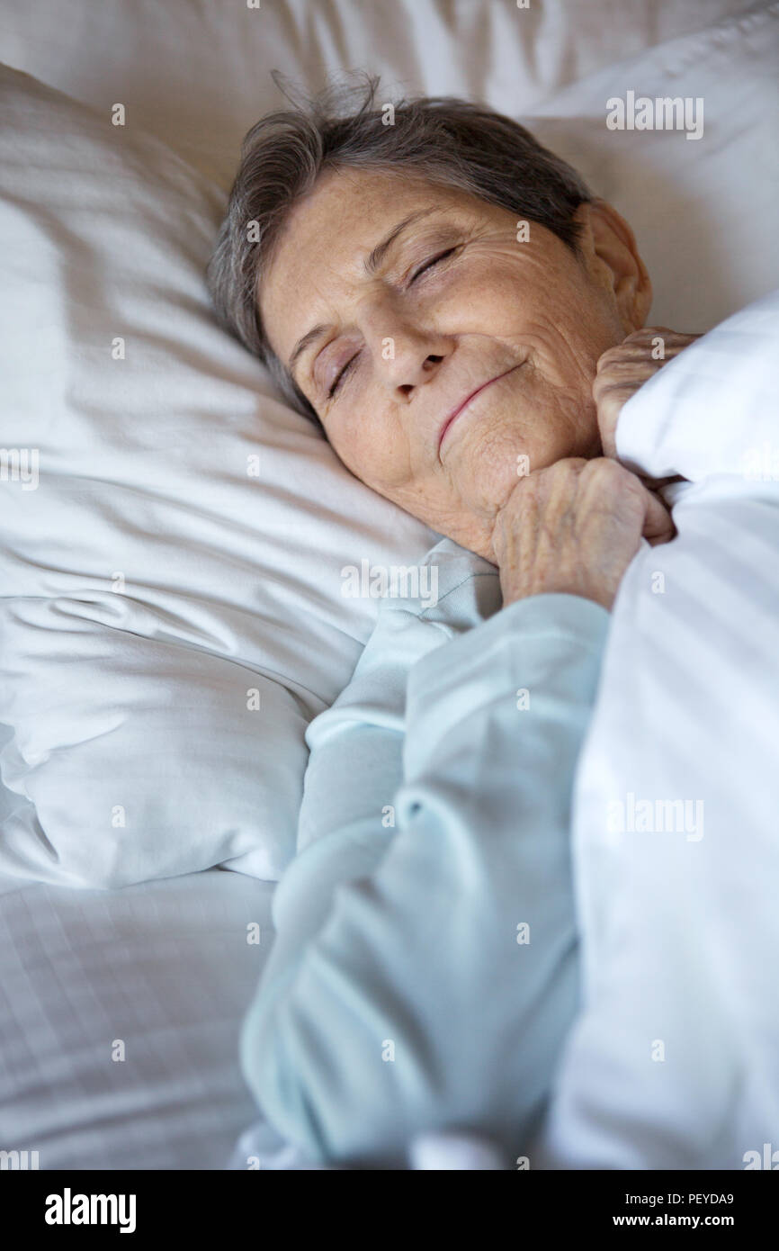 Mature elderly woman getting a good nights rest Stock Photo - Alamy