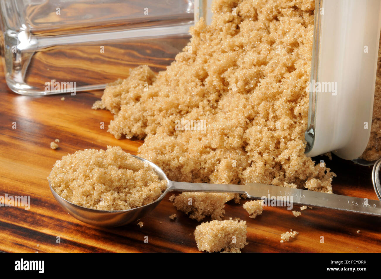 Brown sugar spilling out of a glass canister Stock Photo - Alamy