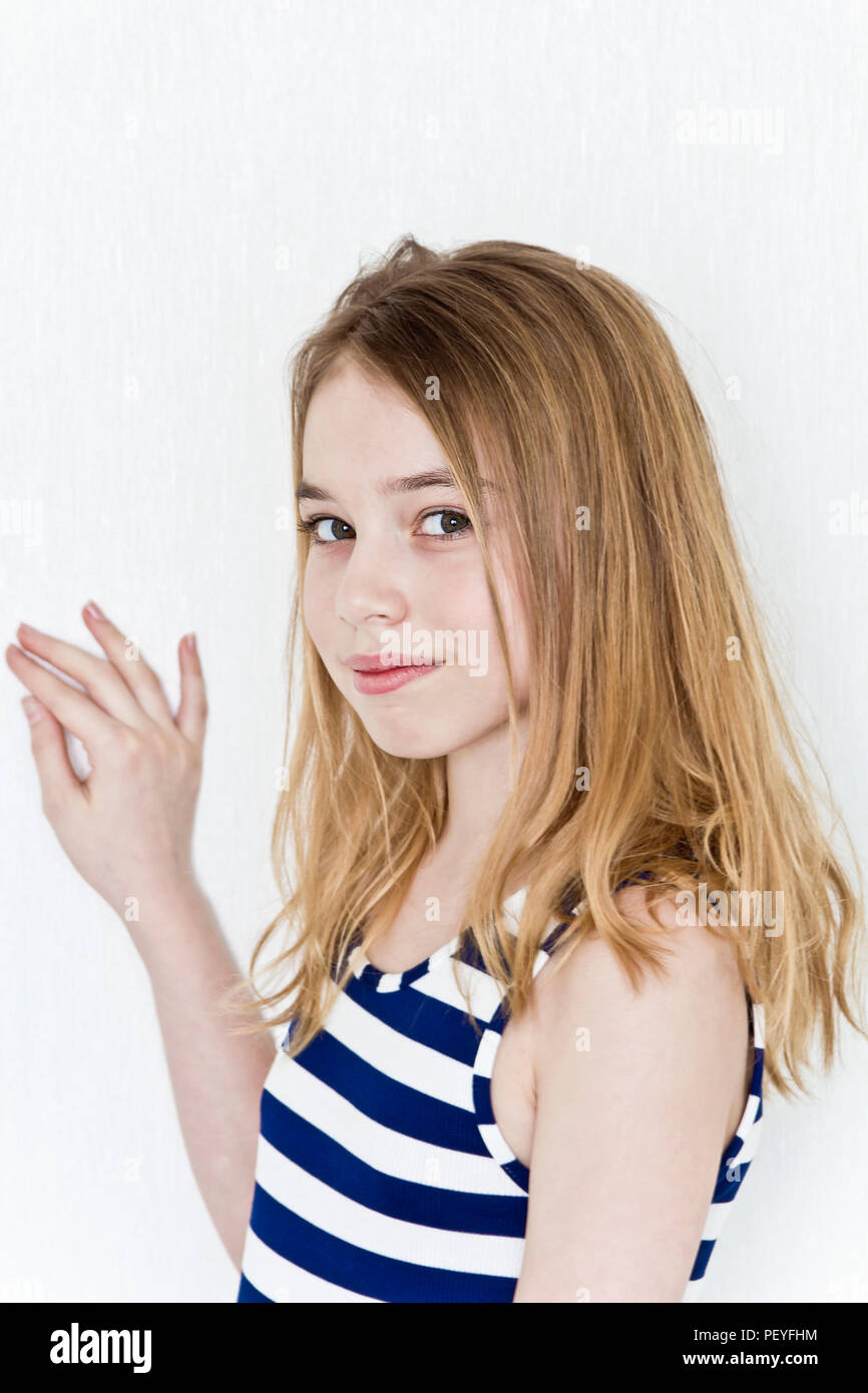 Cute girl eleven years old with blond long hair on white background ...