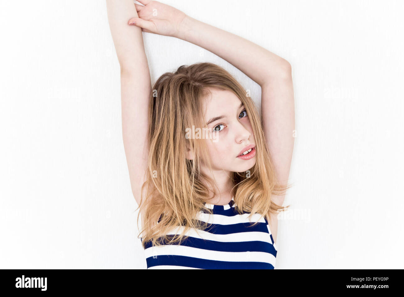 Girl eleven years old standing near white wall and upwards hands Stock ...