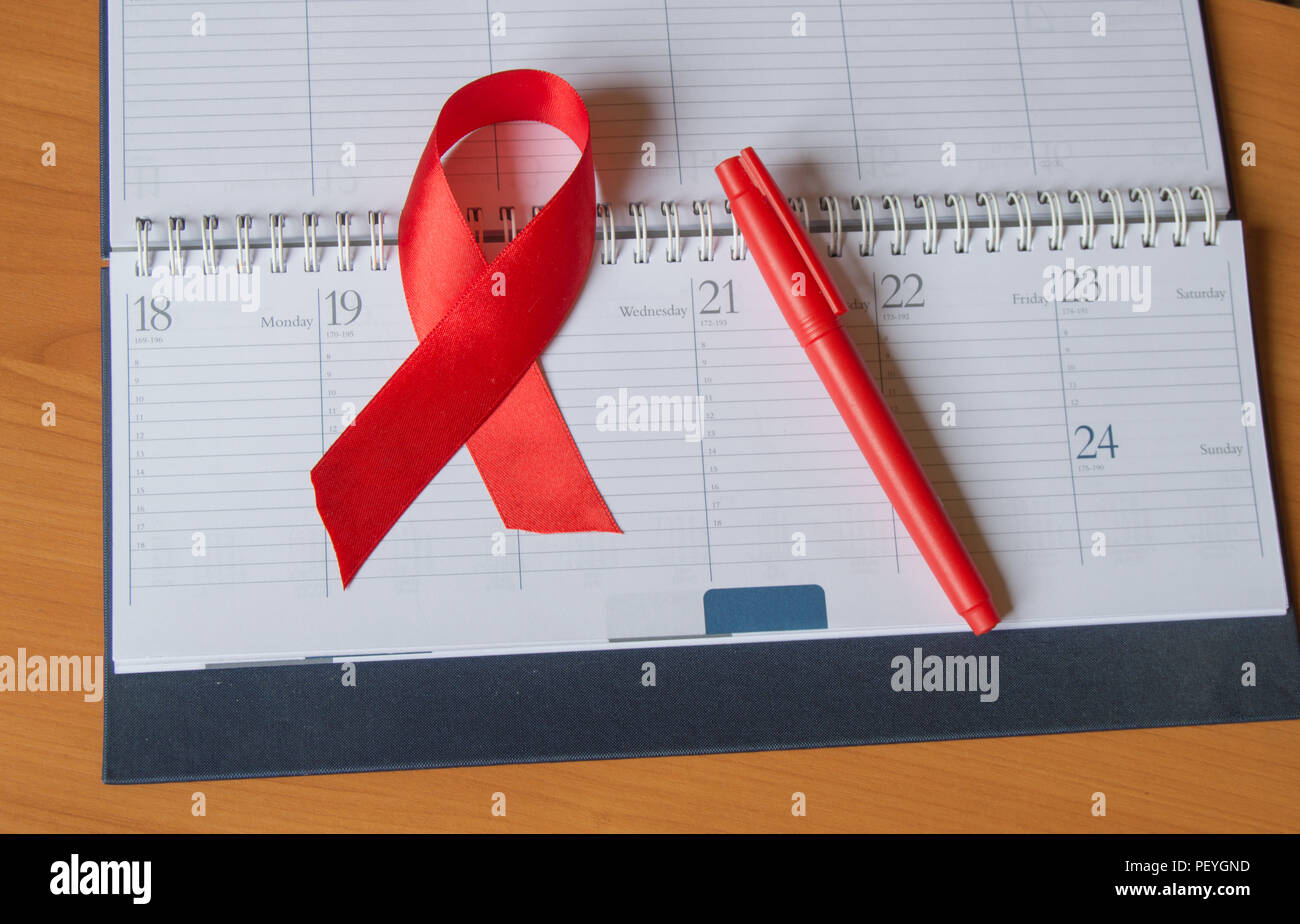 Red ribbon on the calendar to raise awareness against AIDS copy space ...
