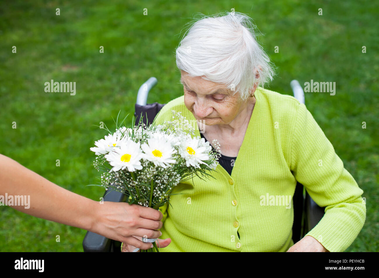 Elderly woman suffering from dementia disease receiving flowers for her ...