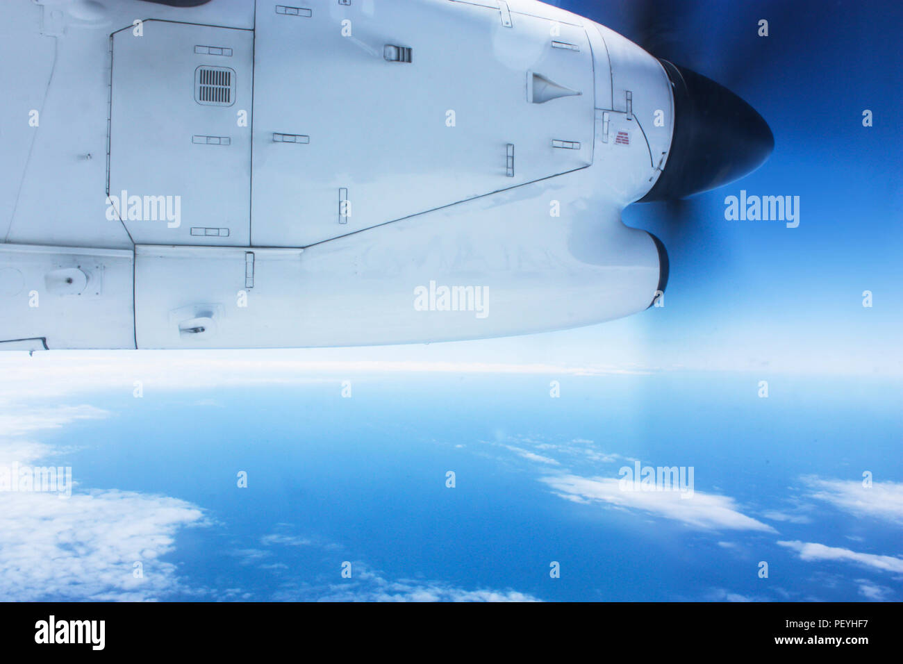 Airplane rotor moving in air flying over the clouds in the blue sky ...