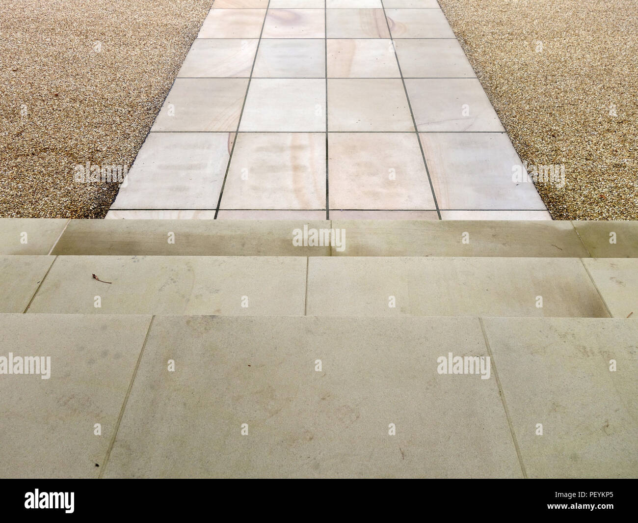 Modern stone slabs forming pathways around a paved area and a formal ...