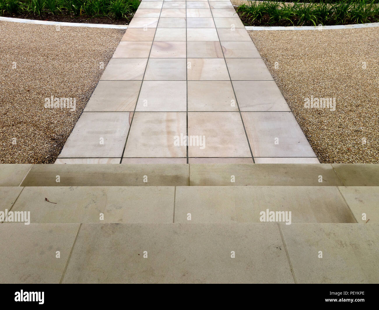 Modern stone slabs forming pathways around a paved area and a formal ...