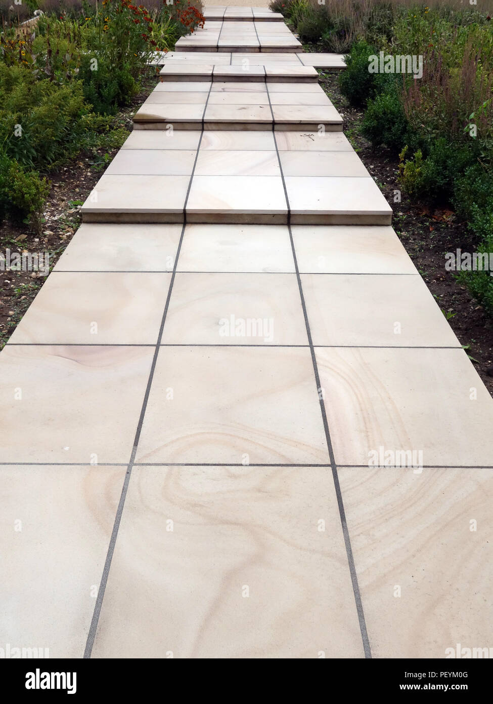Modern stone slabs forming pathways around a paved area and a formal ...