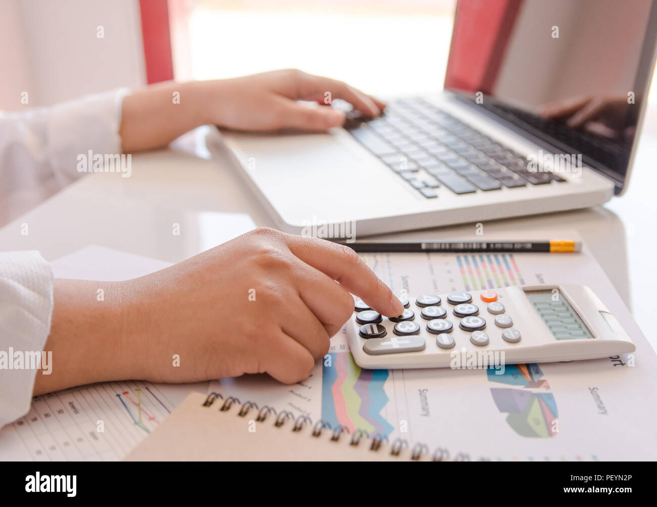 close up business woman hand using calculator and laptop doing counting ...